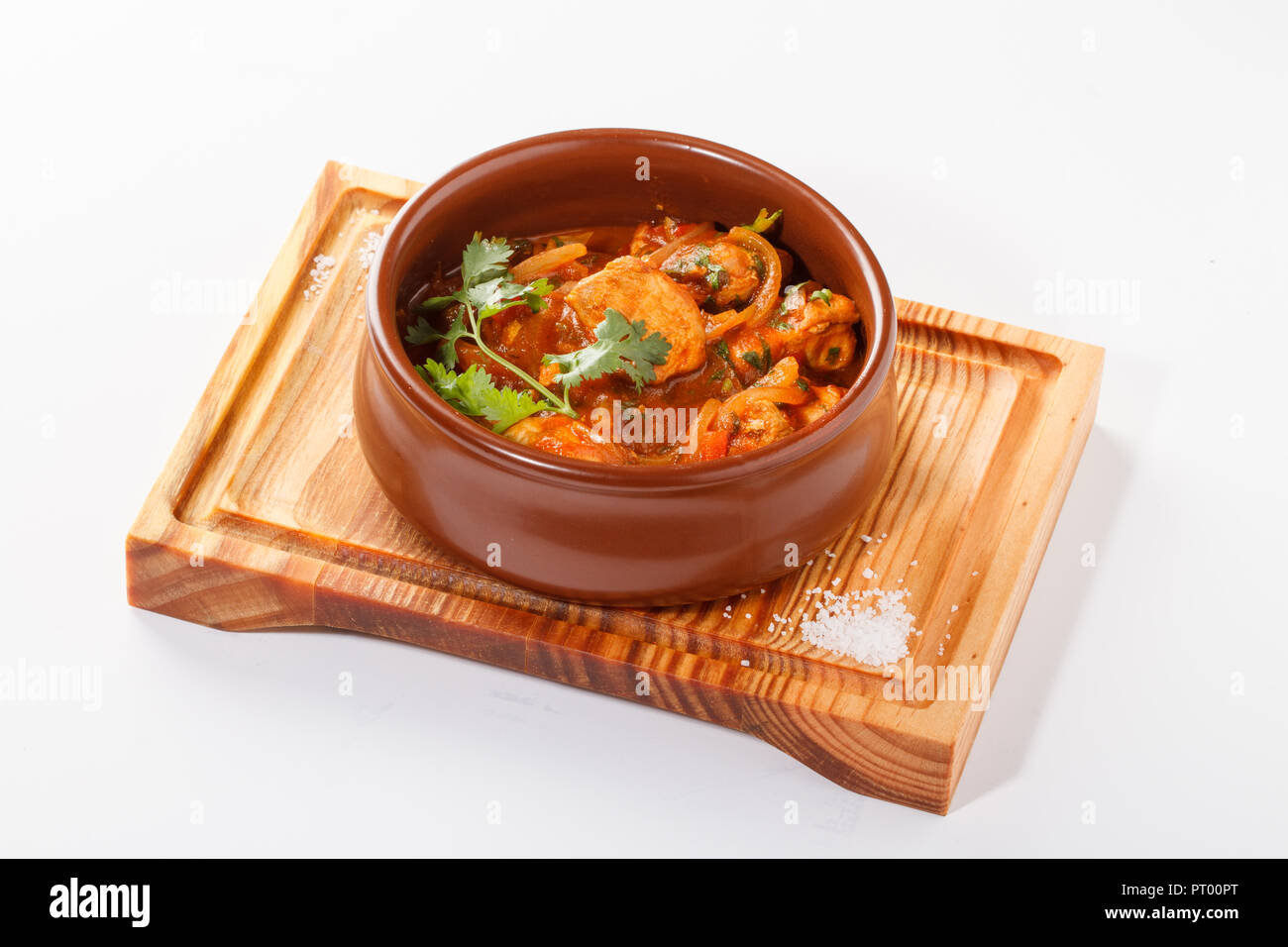 Chicken curry served in a Clay pot/Bowl served on a wooden board ...