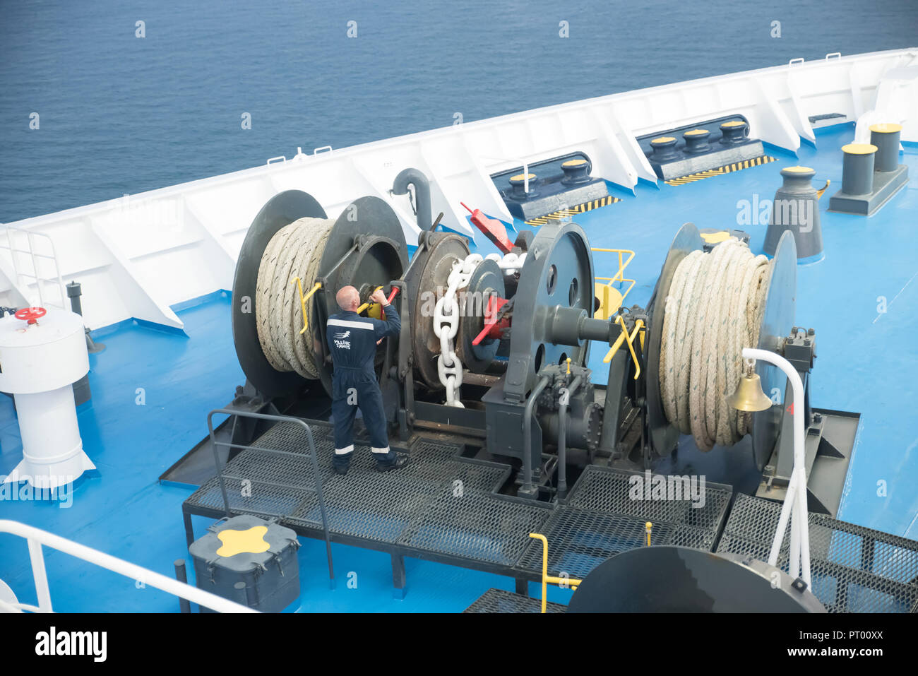 Aegean Sea, Greece/ July 17, 2018: Seaman working on foredeck of ferry ...