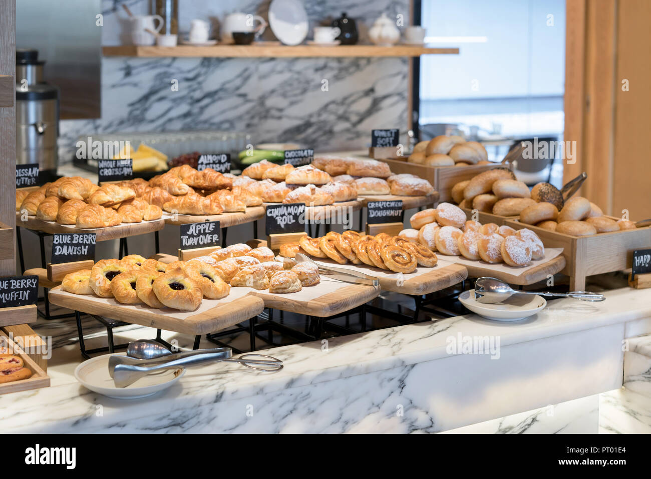 Breakfast lines of different flavor danishs, buns and muffins in wooden ...