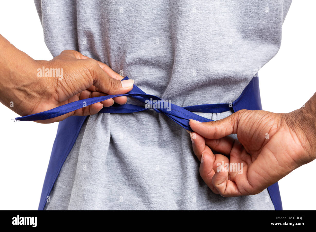 Hypermarket or supermarket employee tying blue apron knot behind back ...