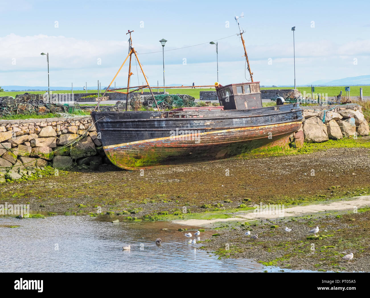 An old fishing boat next to the River Corrib in the Claddagh area of ...