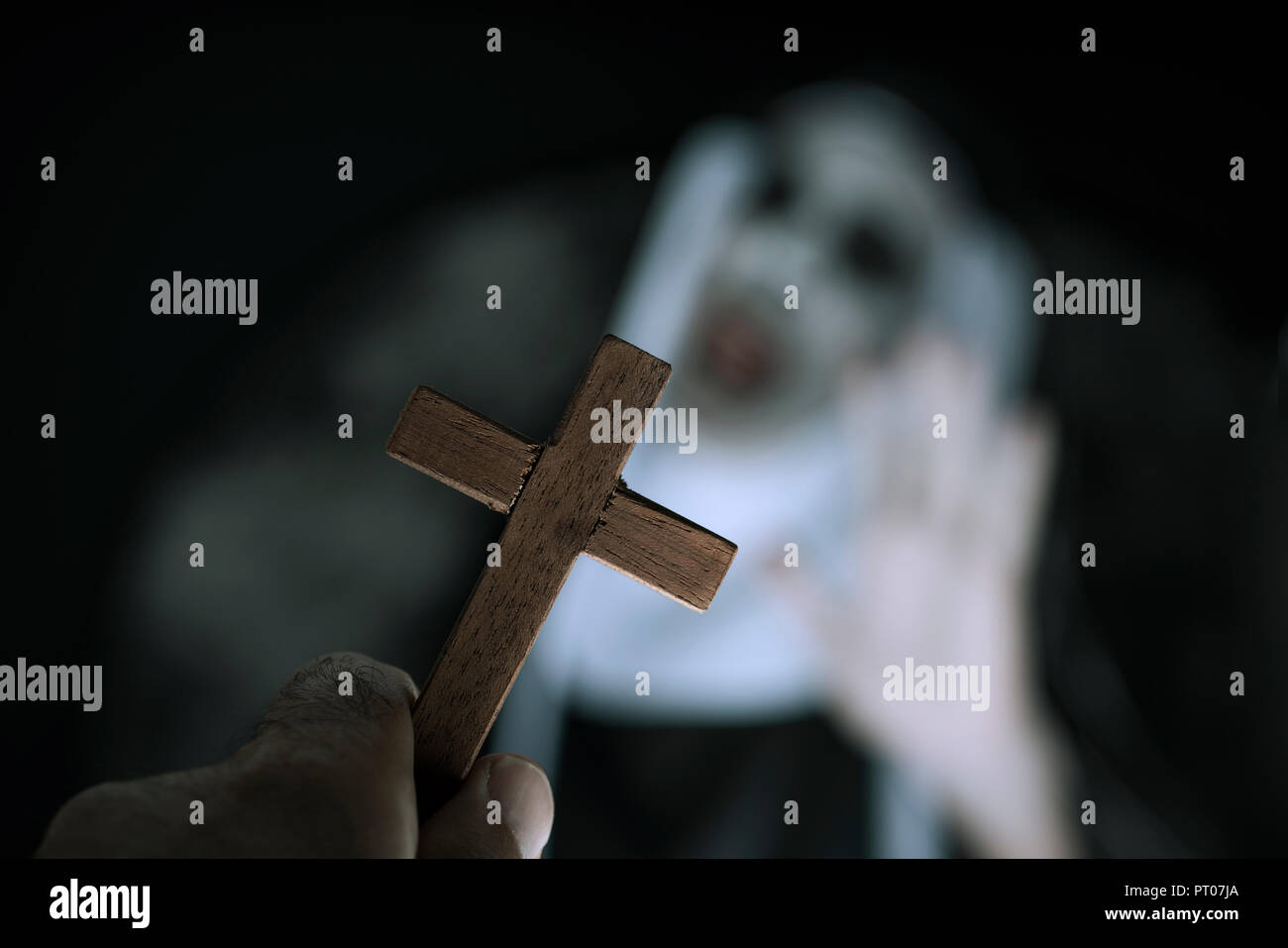 closeup a cross in the hand of a man and a frightening evil nun ...