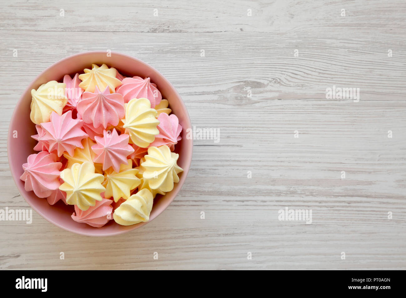 Mini meringues in a pink bowl, top view. Flat lay, overhead, from above ...