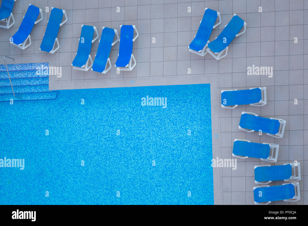 A swimming pool with sun loungers in top view Stock Photo - Alamy
