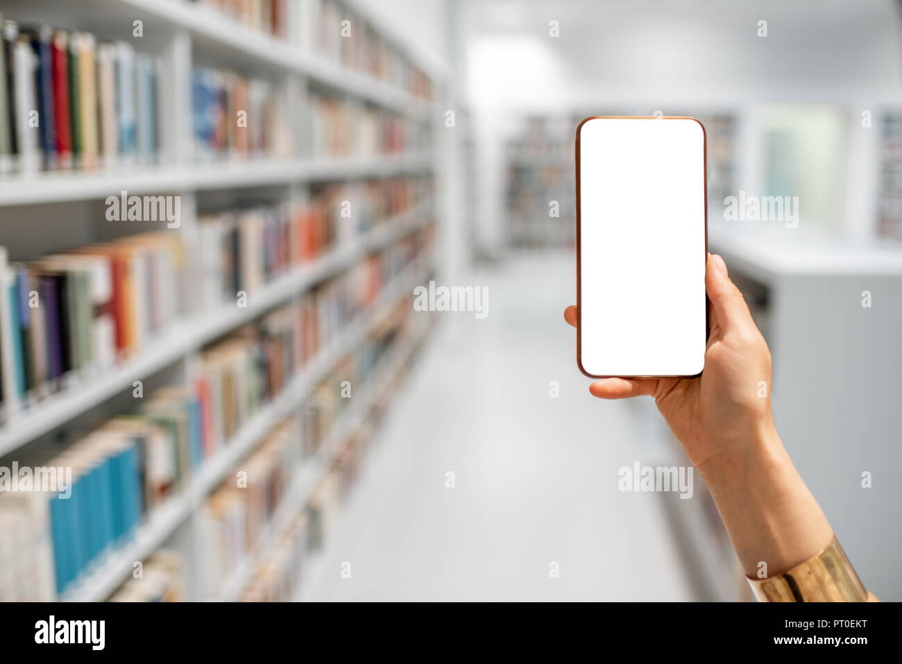 Mockup image of smartphone with modern library interior on the ...