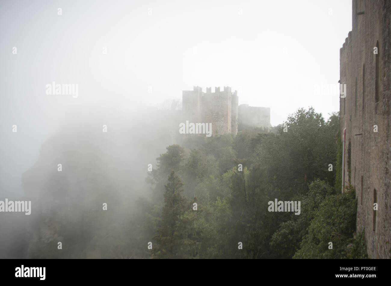 Beautiful medieval castle on a hilltop half covered with clouds Stock ...