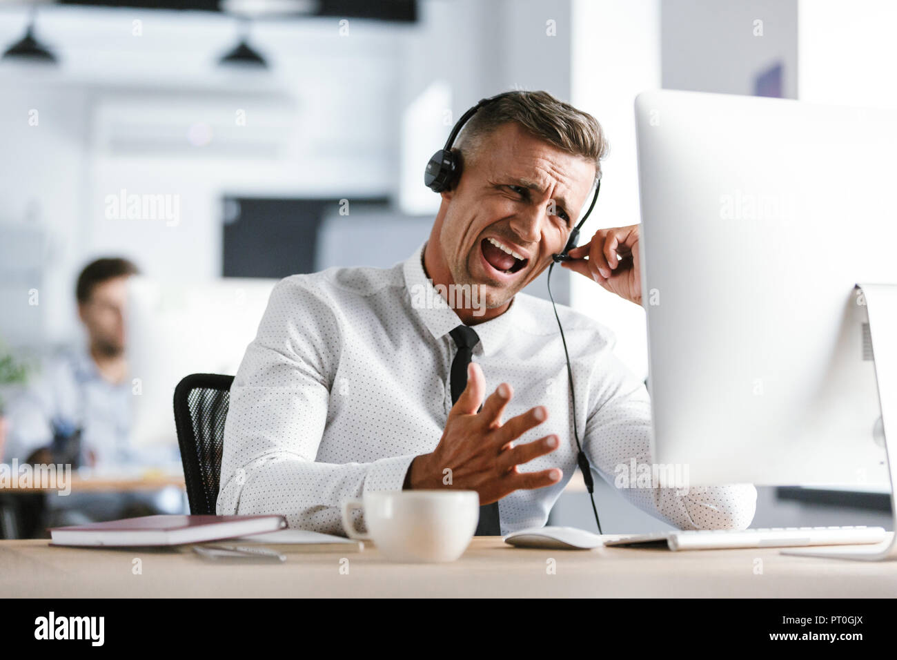 Photo of nervous businessman 30s wearing office clothes and headset ...