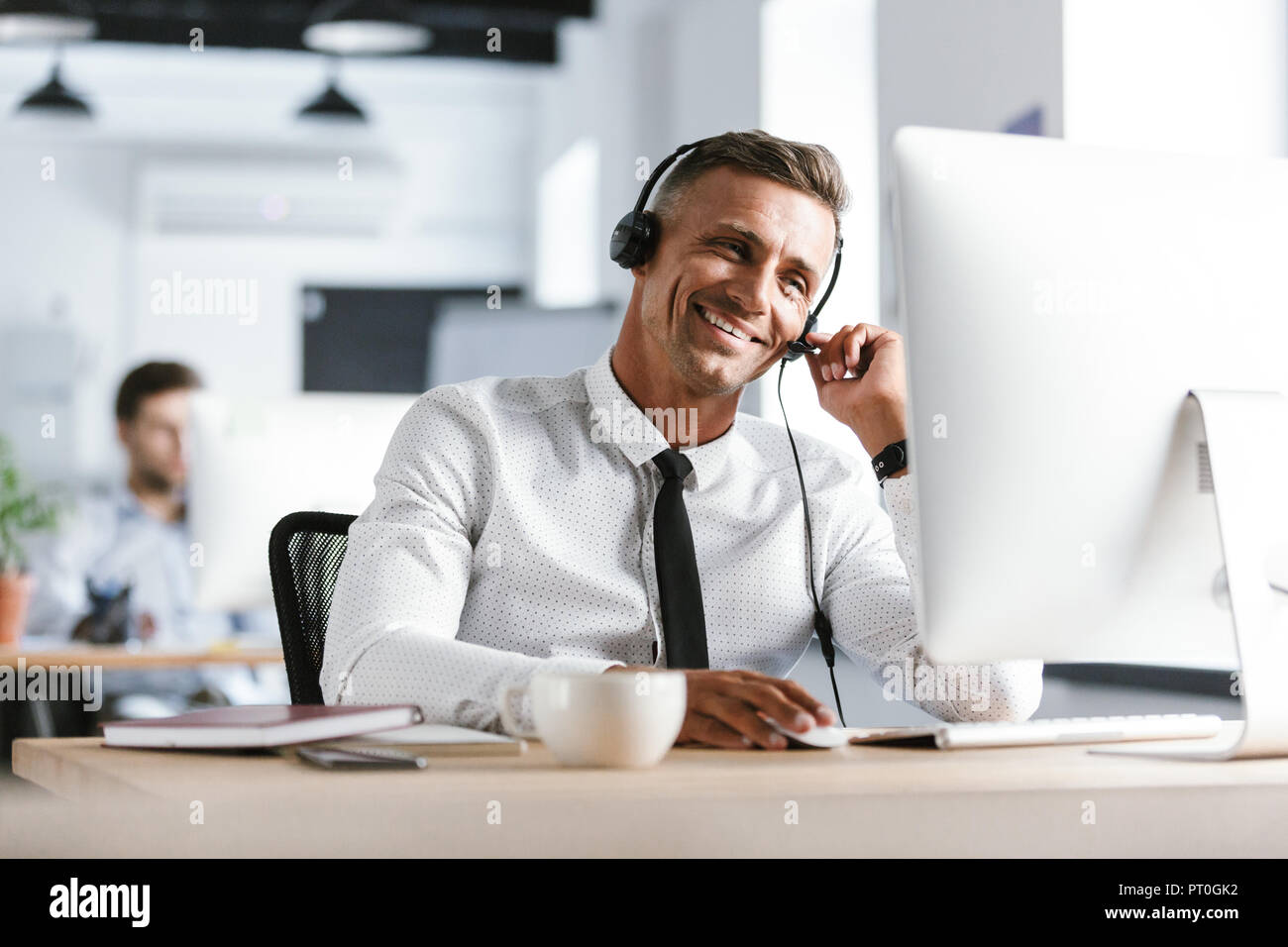 Photo of smiling operator man 30s wearing office clothes and headset ...
