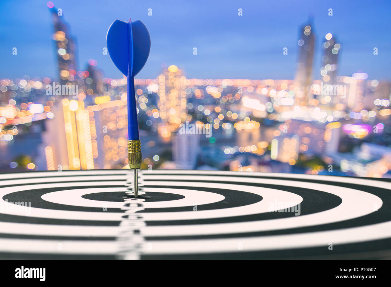 target and goal concept, blue dart on board with night city background ...