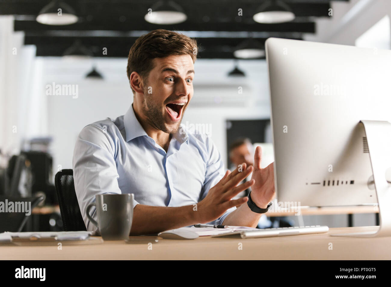 Shocked screaming business man using computer while sitting by the ...