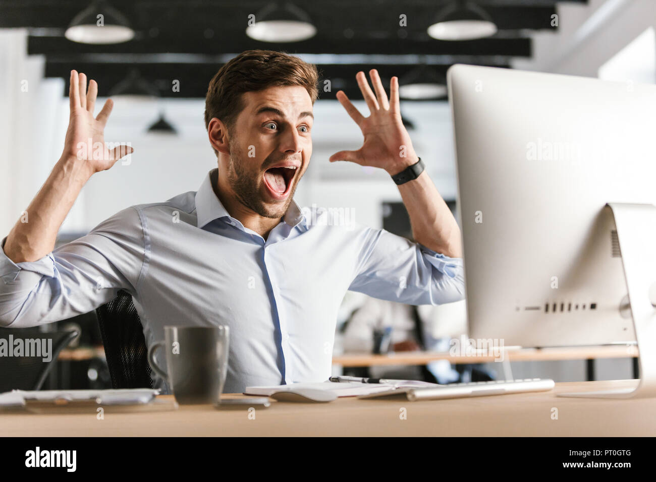 Shocked screaming business man using computer and rejoices while ...