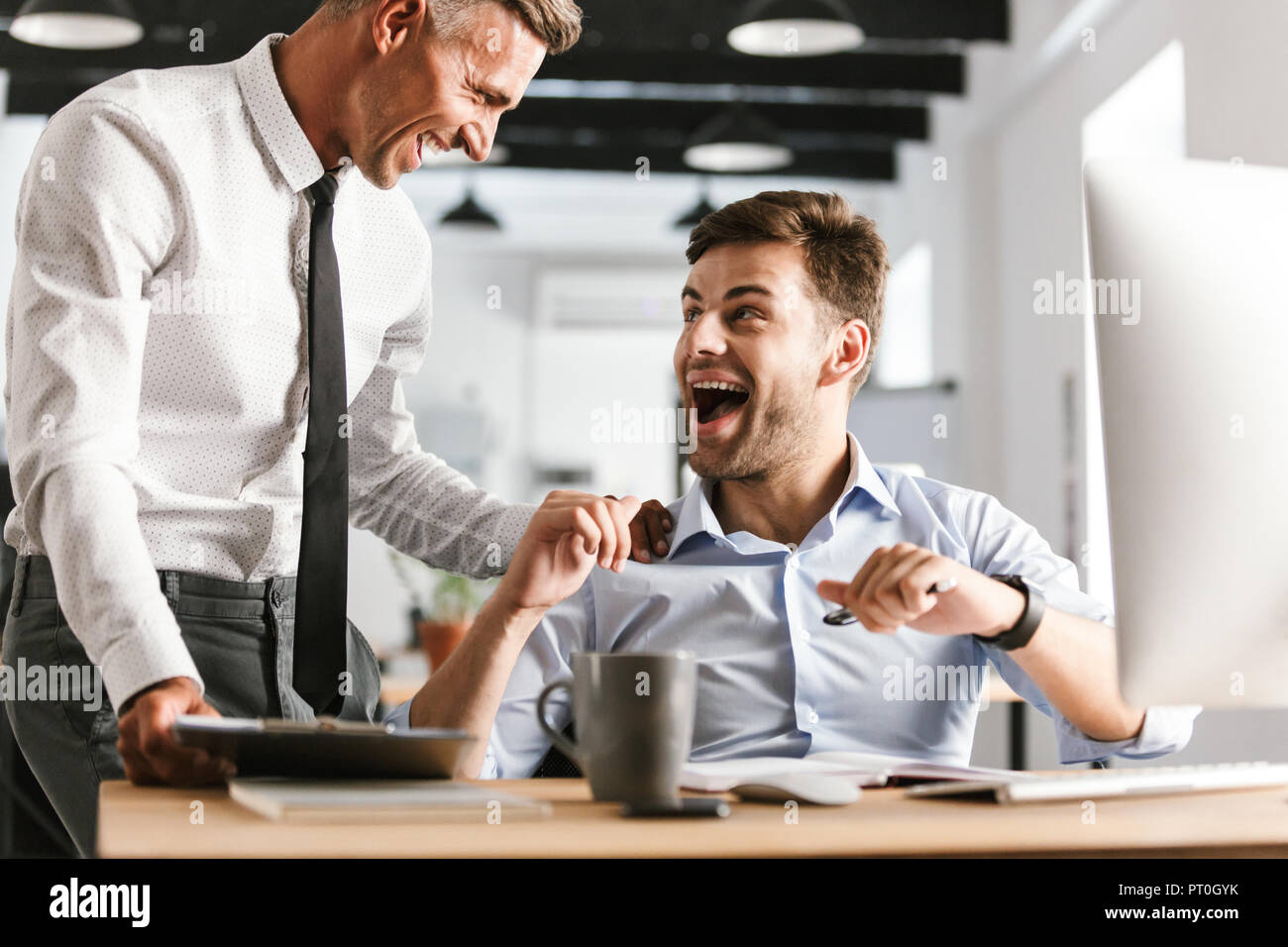 Picture of excited surprised shocked happy emotional men colleagues in ...