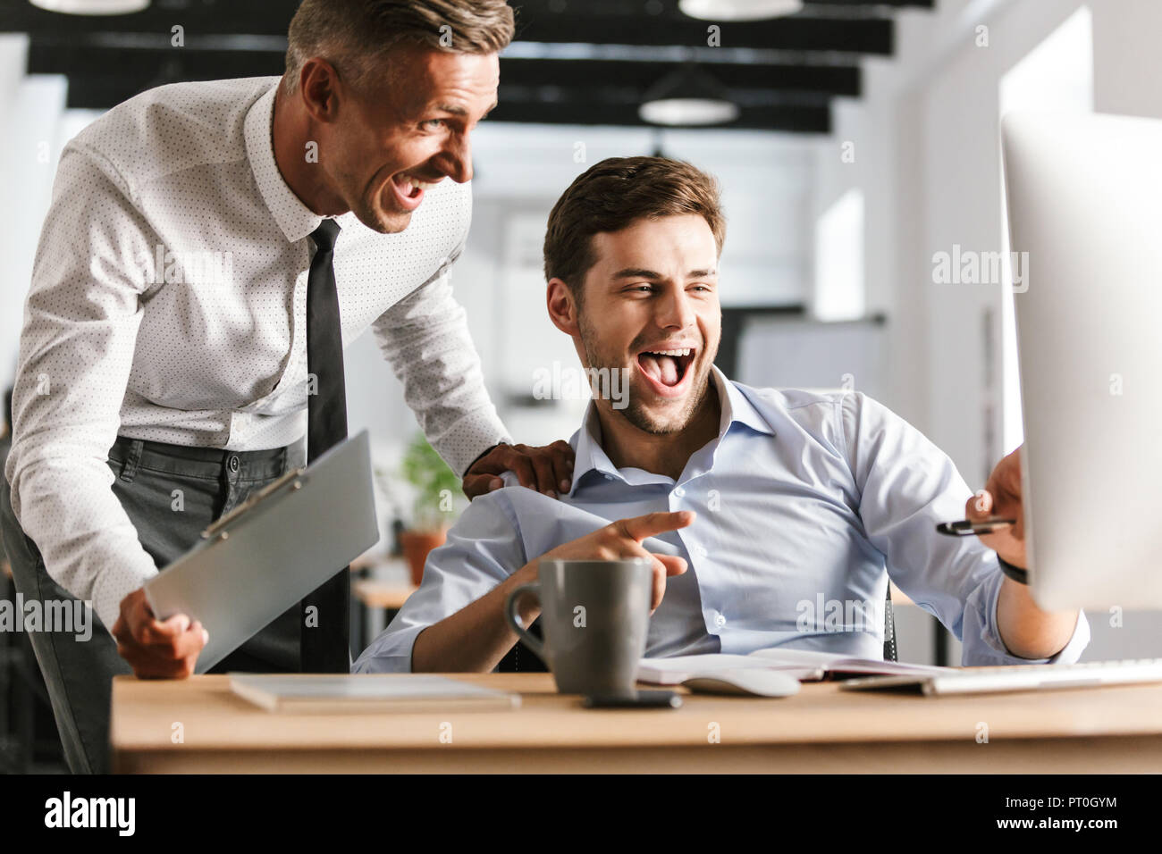 Picture of excited happy emotional men colleagues in office working ...