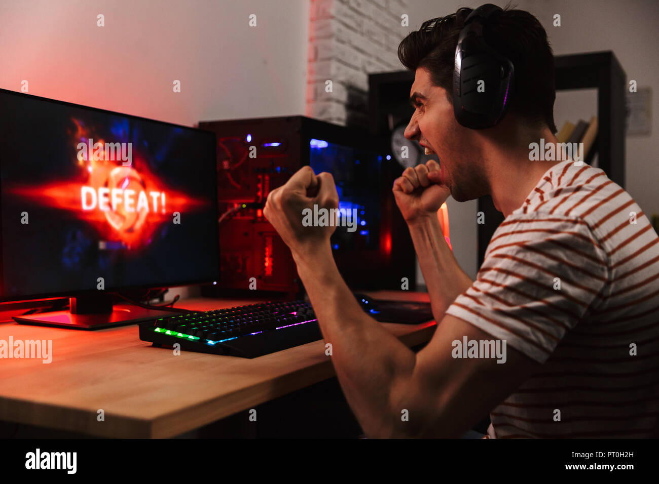 Side view of Screaming displeased gamer playing video games on computer ...