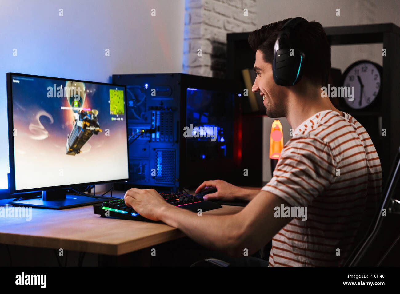 Portrait of young gamer man playing video games on computer wearing ...