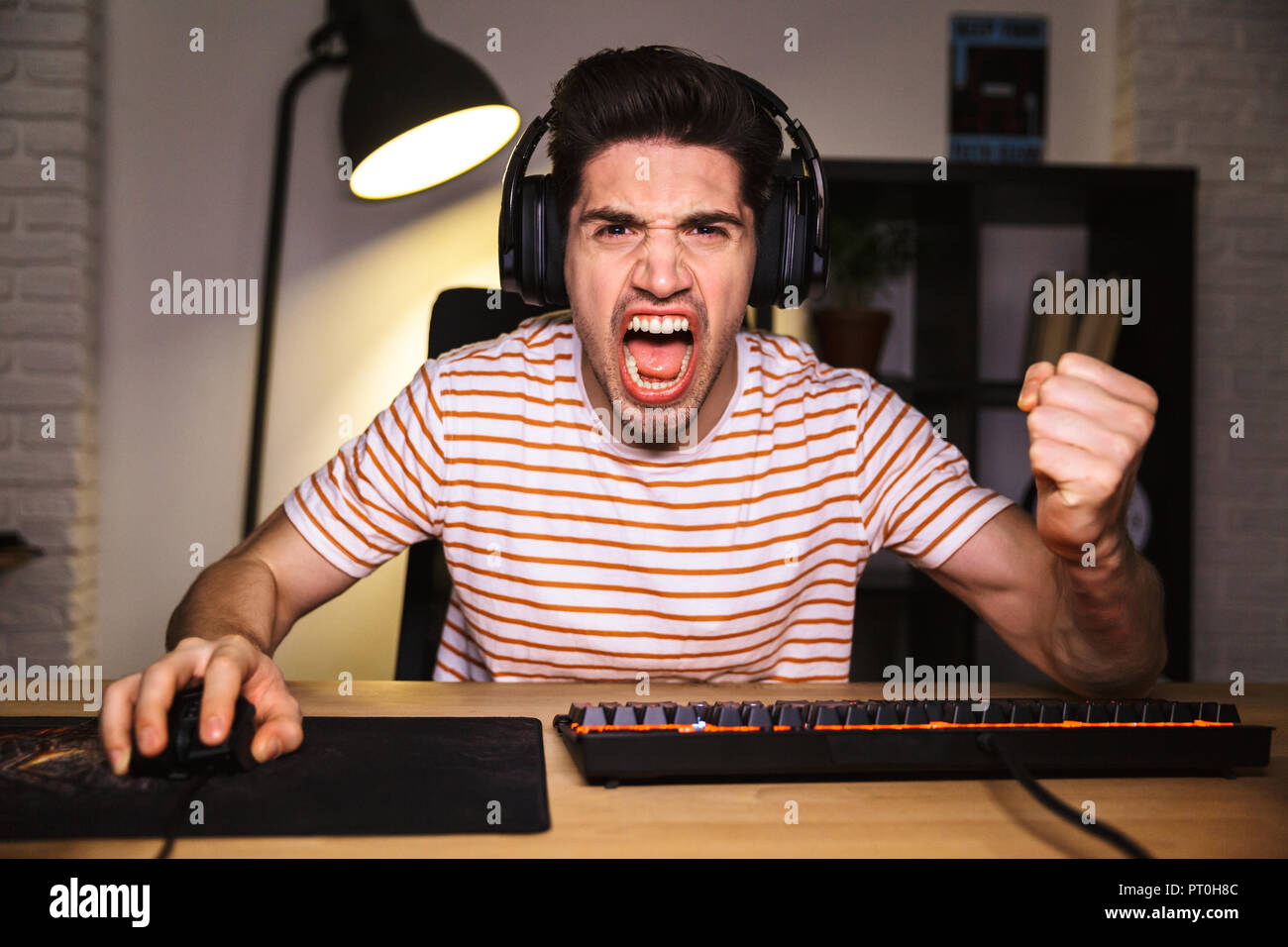 Portrait of caucasian excited gamer guy shouting while looking at ...