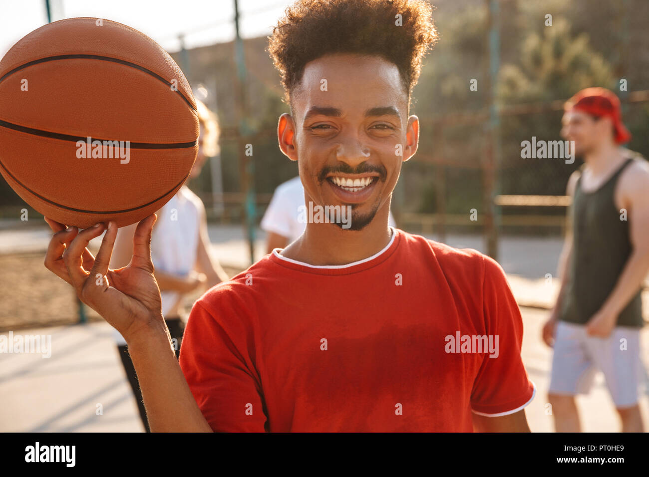 Portrait of american guy spinning ball on his finger while playing ...