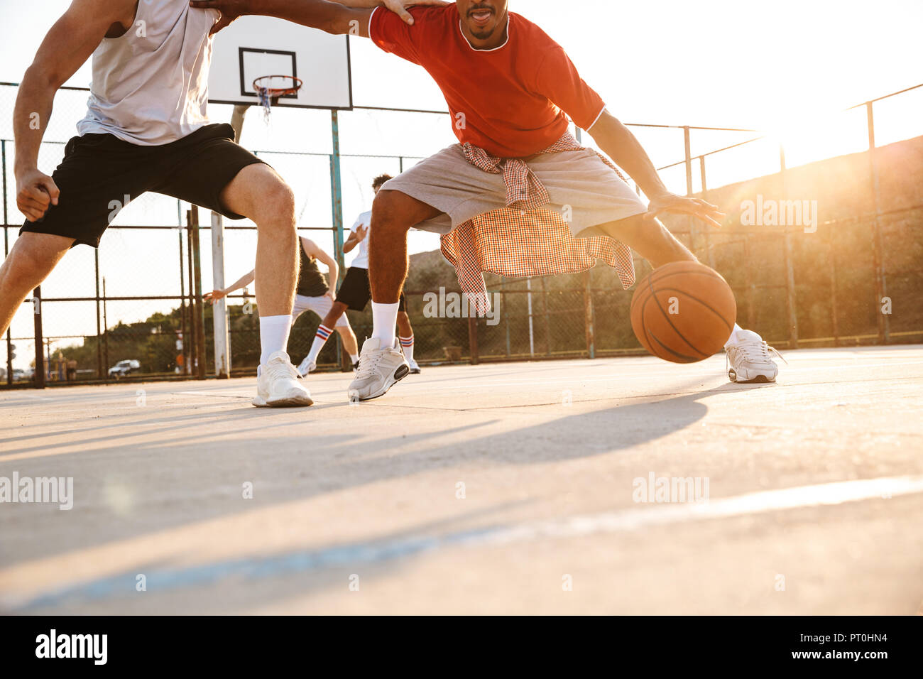 Cropped image of young multiethnic men basketball players playing ...