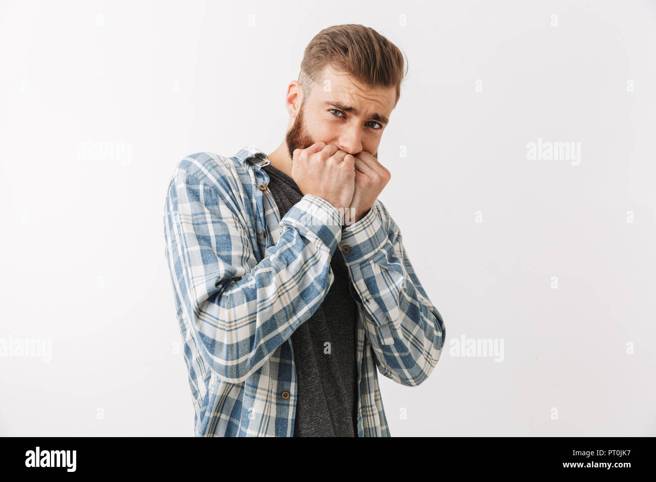Portrait of a scrared young bearded man standing isolated over white ...