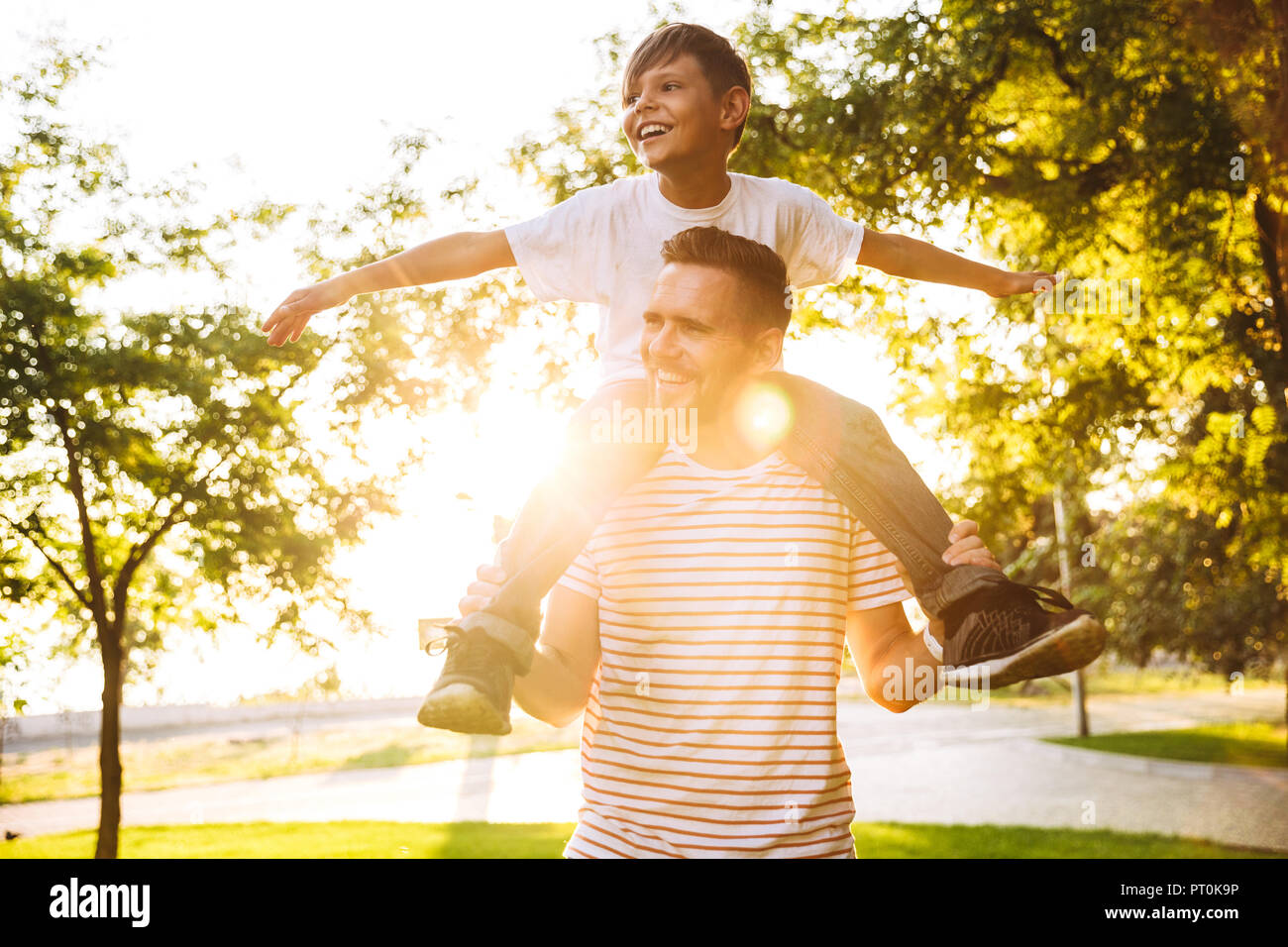Image of happy young man father having fun with his son outdoors in ...