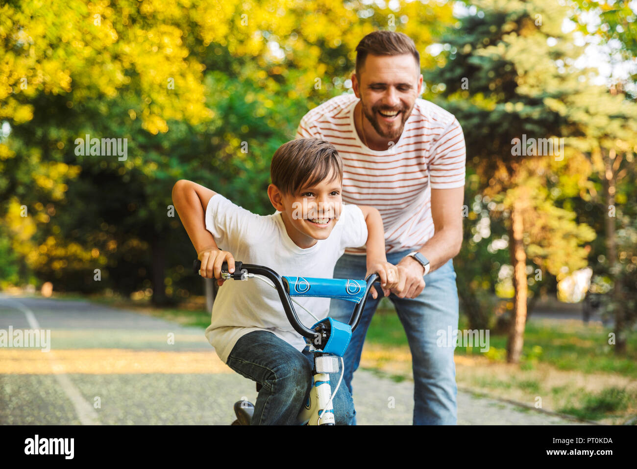Excited father and his son having fun together at the green park ...