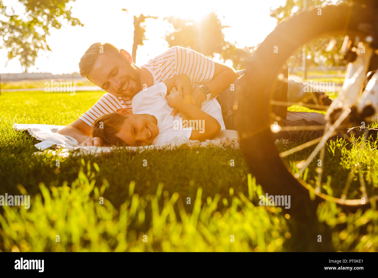 Image of happy young man father having fun with his son outdoors in ...