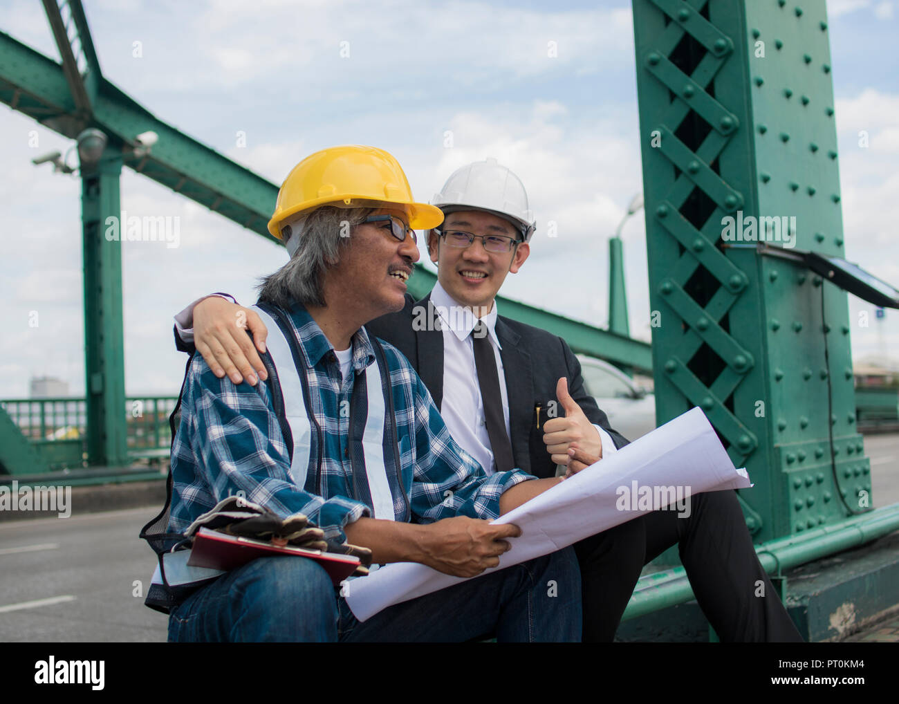 building contractor and engineer sitting and showing thumb to admire at ...