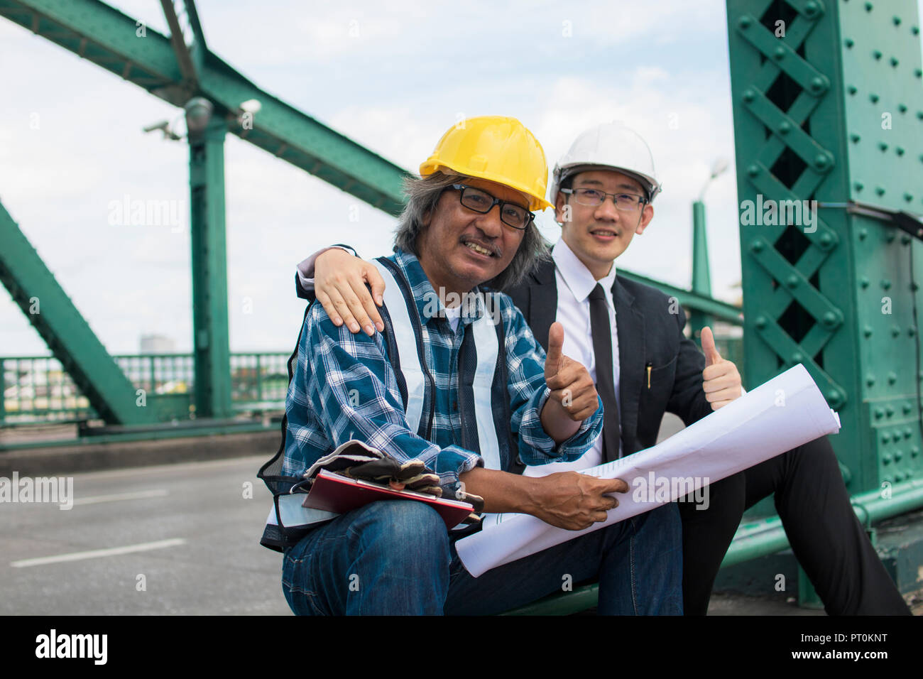 building contractor and engineer sitting and showing thumb to admire at ...