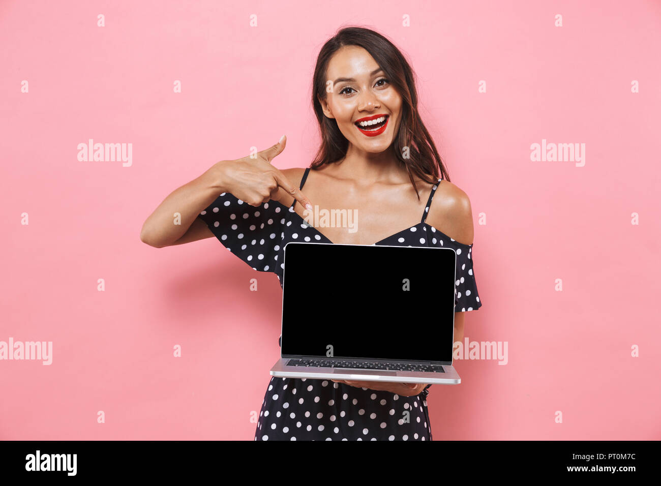 Photo of excited beautiful woman isolated over pink background showing ...