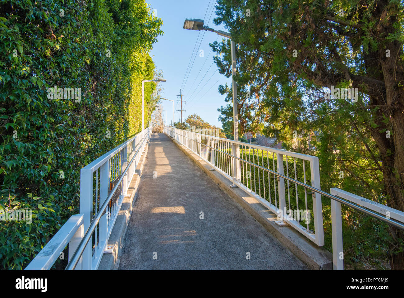 A concrete ramp and steel railings leading to the overpass from the ...