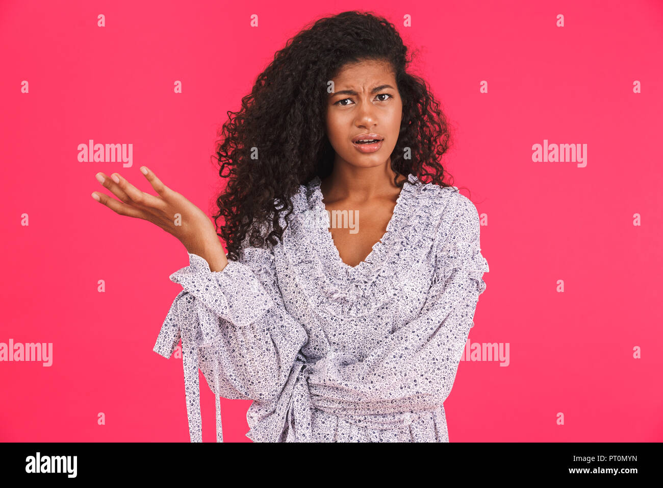 Portrait of a confused young african woman in summer dress standing ...