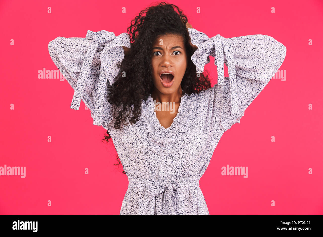 Portrait of a shocked young african woman in summer dress standing ...