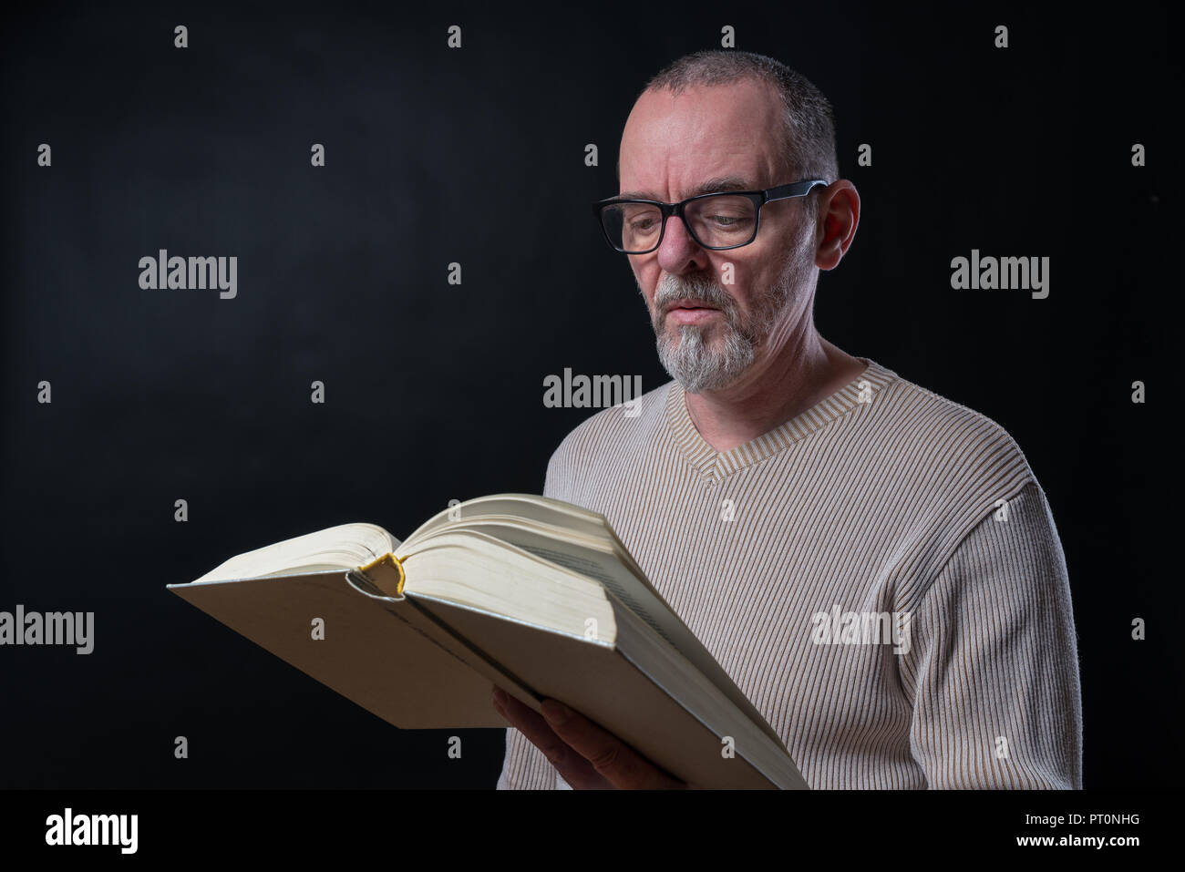 old man with glasses reading a book Stock Photo - Alamy