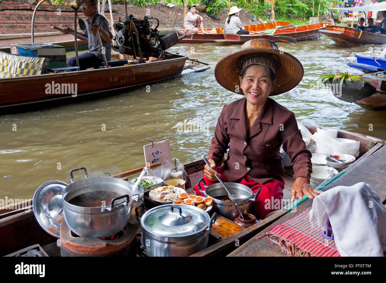 Female food vendor wearing traditional large straw hat at the Damnoen ...