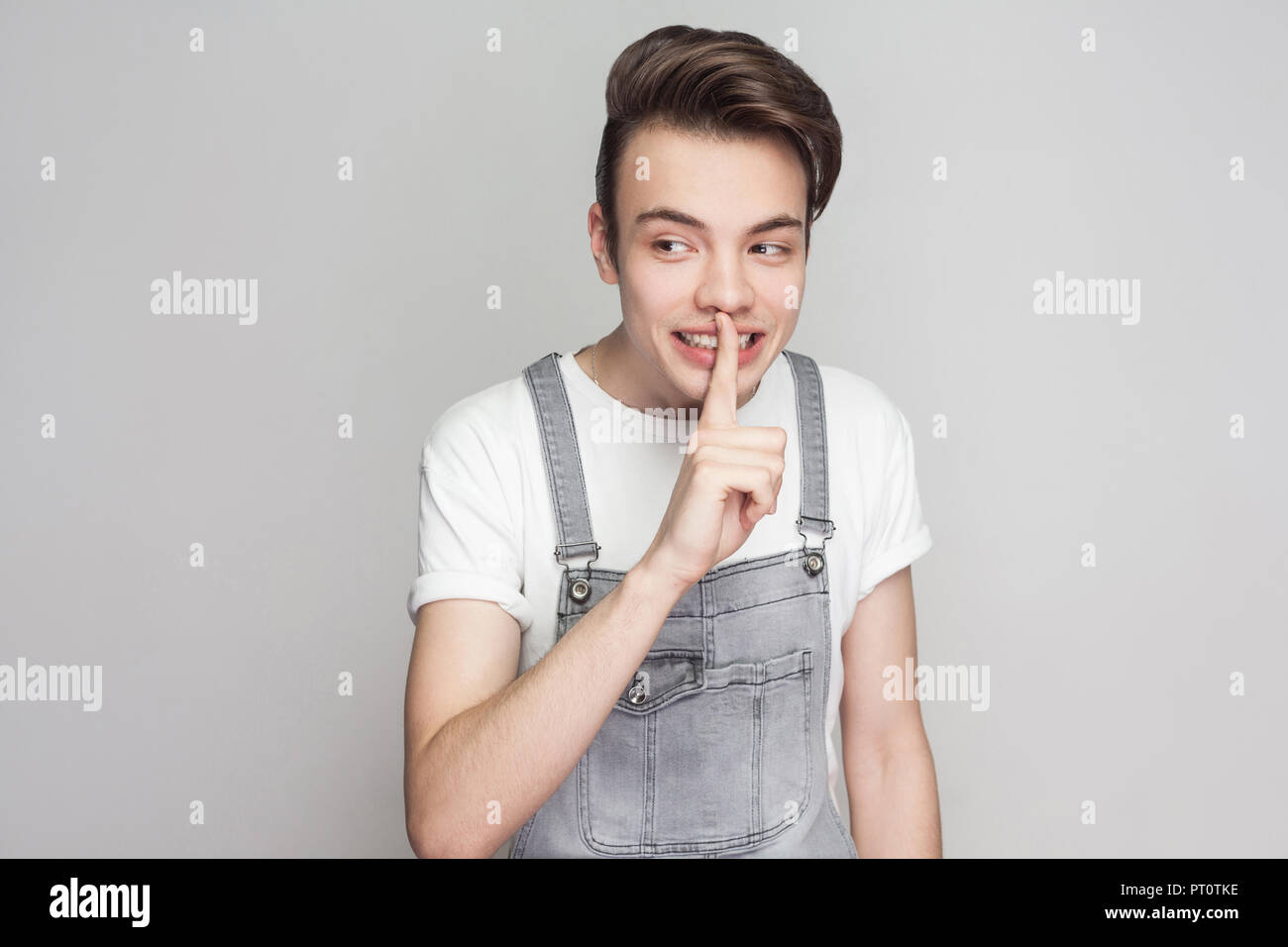 Shh sign. funny young brunette man in casual style with white t-shirt ...