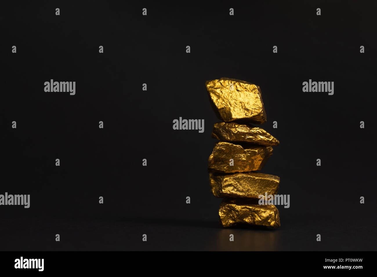 A pile of gold nuggets or gold ore on black background, precious stone ...