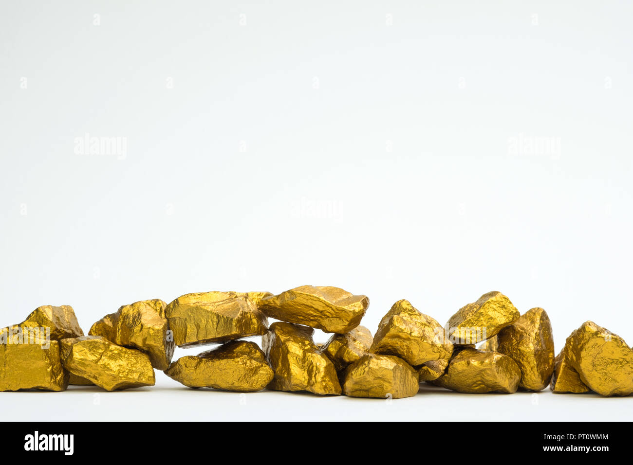 A pile of gold nuggets or gold ore isolated on white background ...