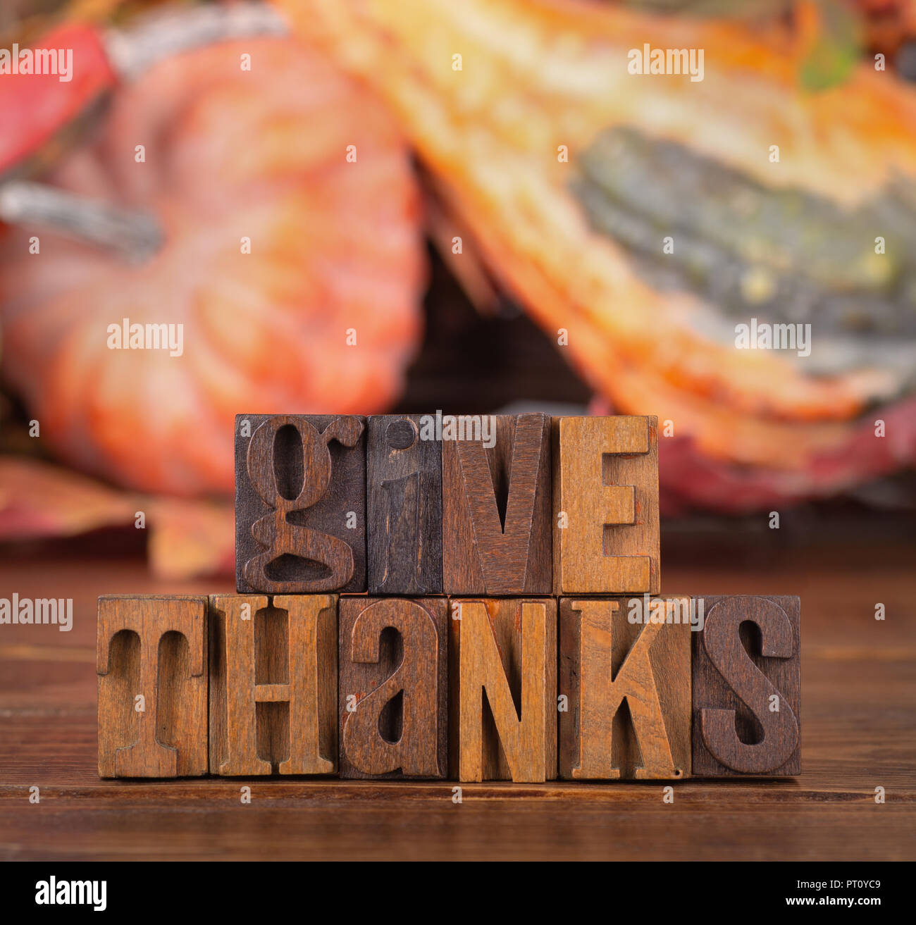Give Thanks written with wooden block lettering on a colorful ...