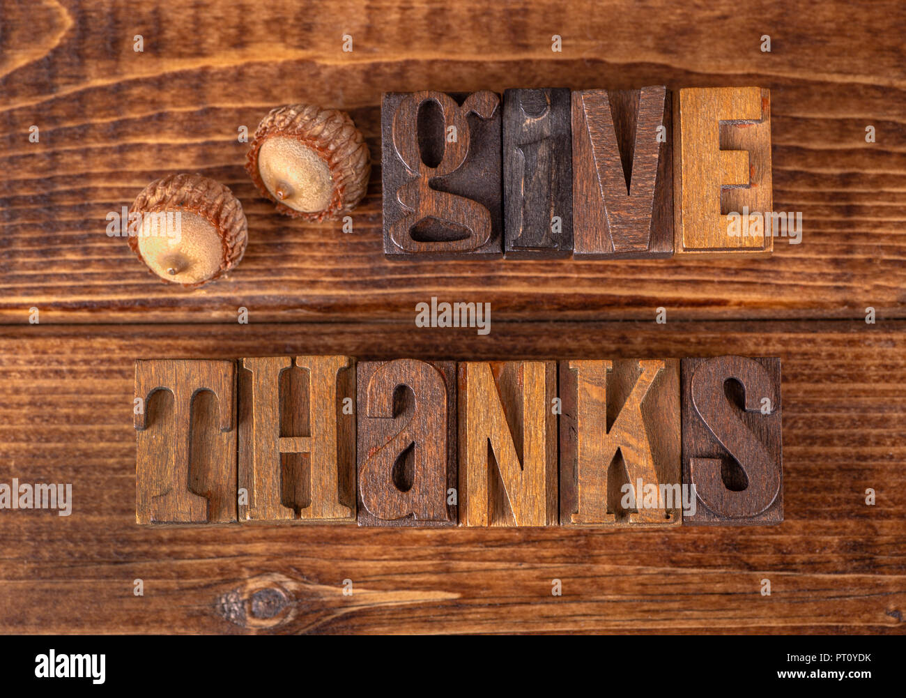 Give Thanks written with wooden block lettering on a rustic wooden ...