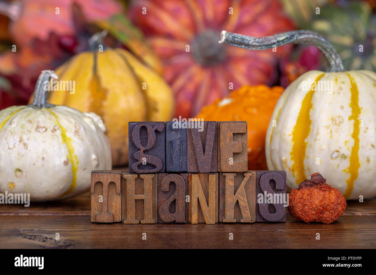 Give Thanks text written with wooden block letters on a colorful ...