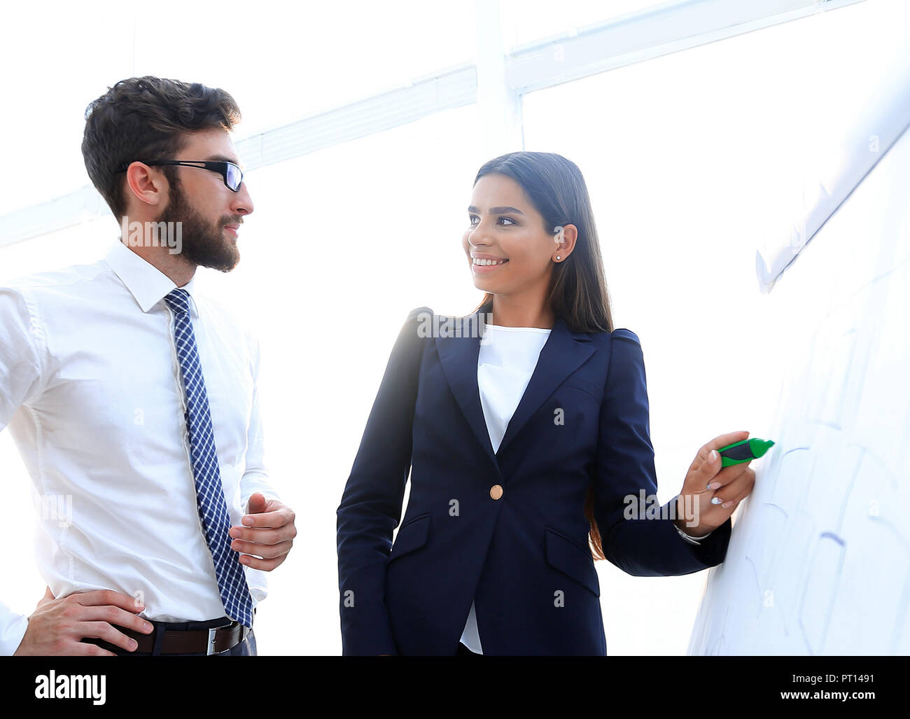 businesswoman pointing marker to flipboard on presentation in office ...