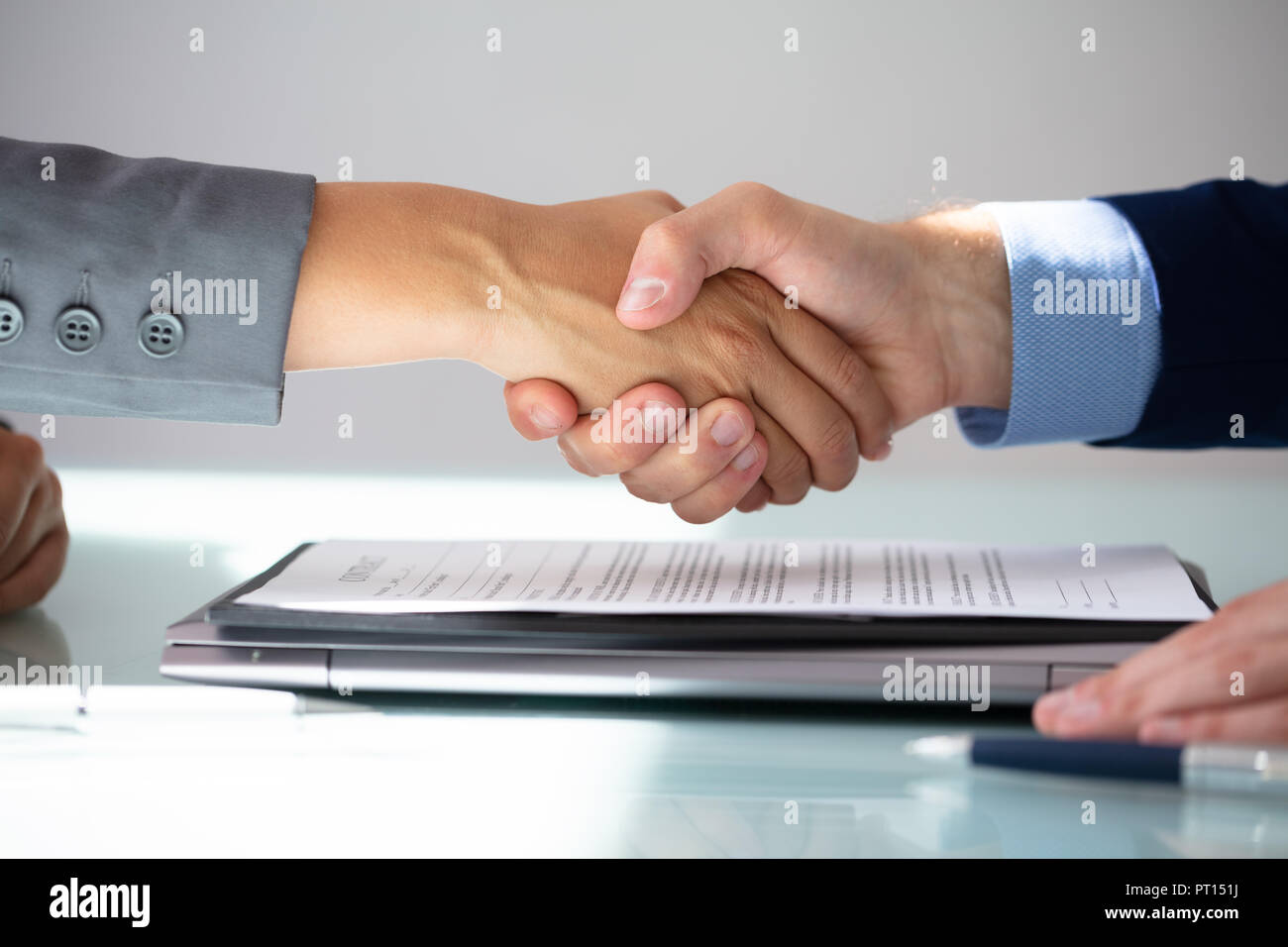 Business Partners Shaking Hands Over Contract Form Stock Photo - Alamy