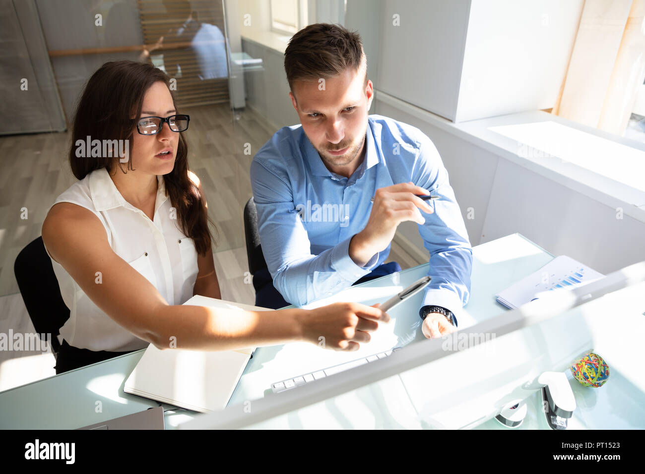 Two Professional Young Businesspeople Looking At Computer Having ...