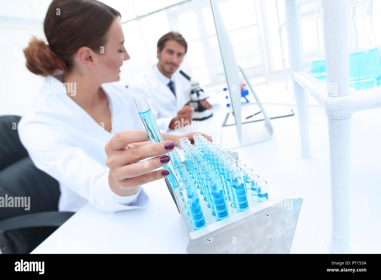 A scientist is working on a computer with a microscope Stock Photo - Alamy