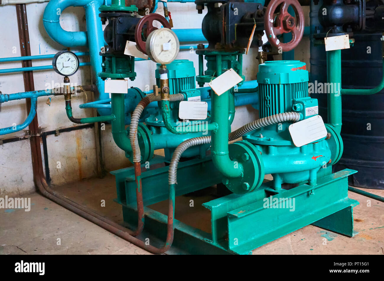 Old green electric motor to the pump, valve and pressure gauge on the ...