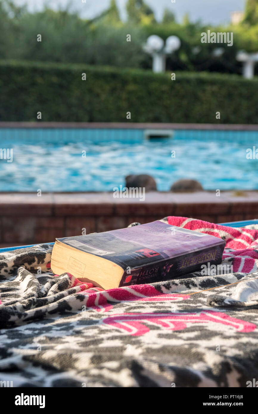 book on a towel, sunbed by the pool, best life concept, relaxing ...