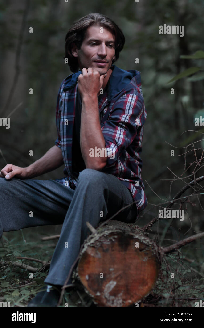 closeup.dreaming of a man sitting on a log in the woods Stock Photo - Alamy