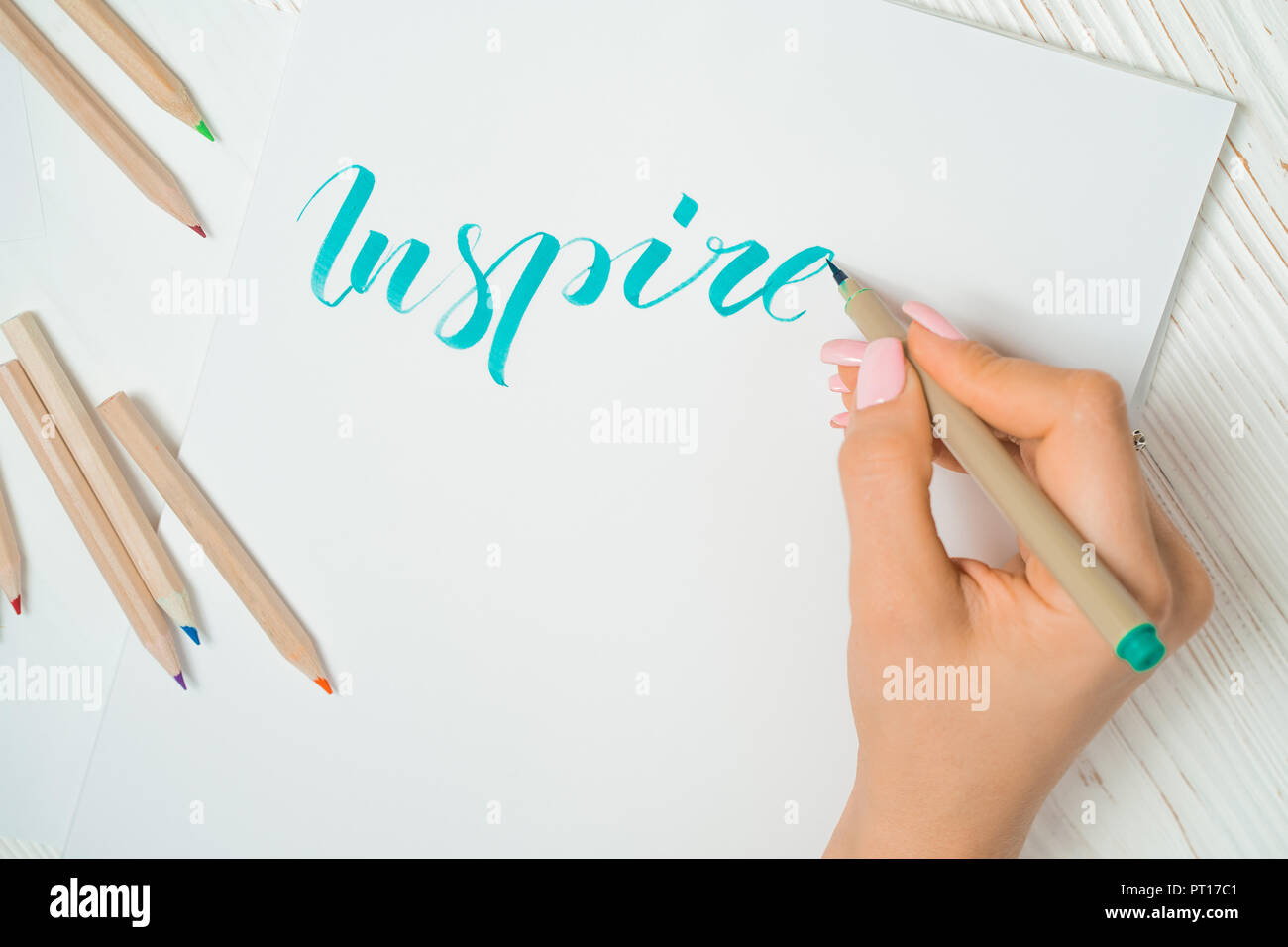 Calligrapher student practices in writing word inspire with green ...