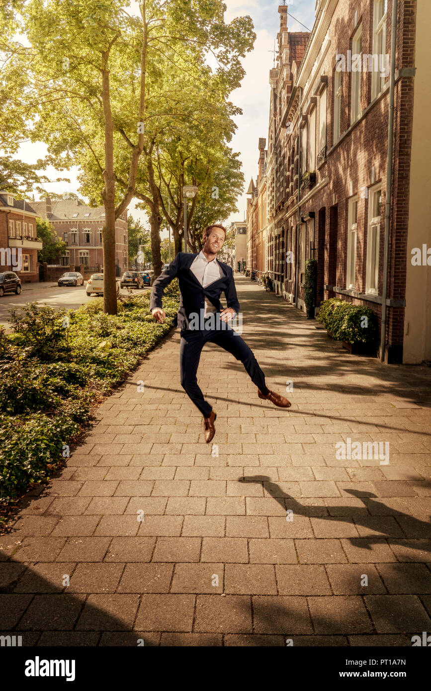 Happy businessman jumping on pavement hi-res stock photography and ...