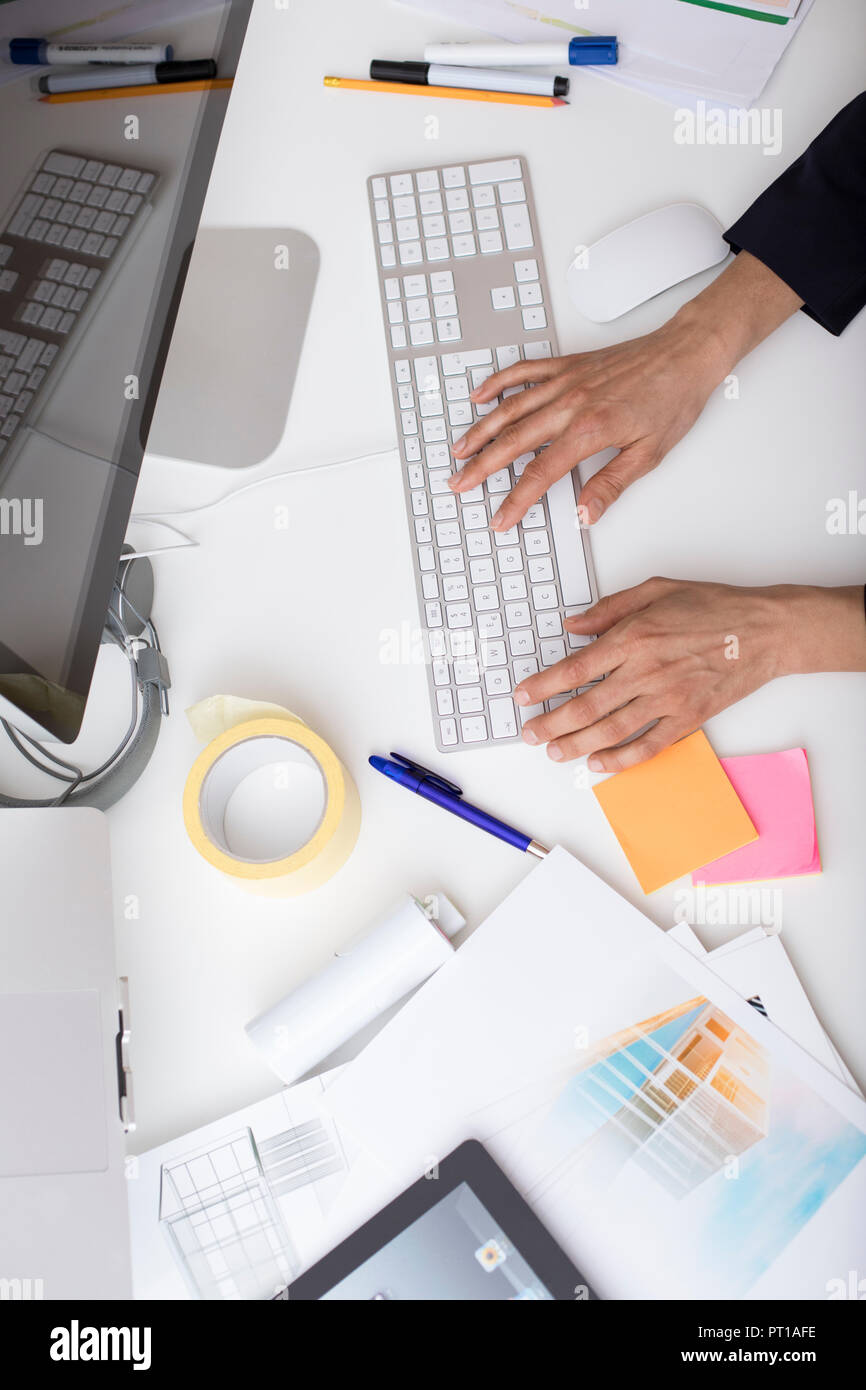 Woman using computer keyboard at desk in office Stock Photo - Alamy